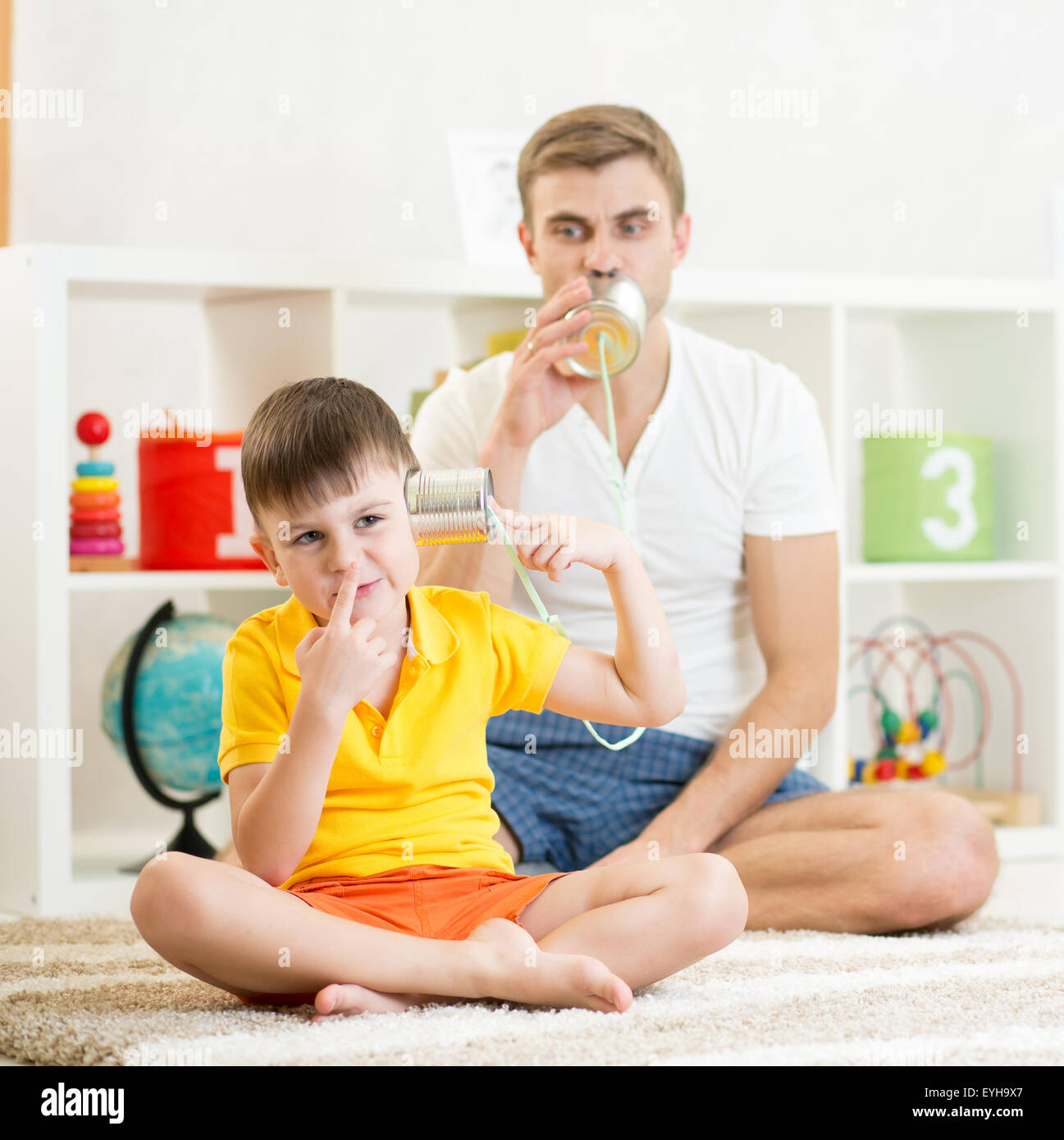 Kid and dad having a phone call with tin cans Stock Photo - Alamy
