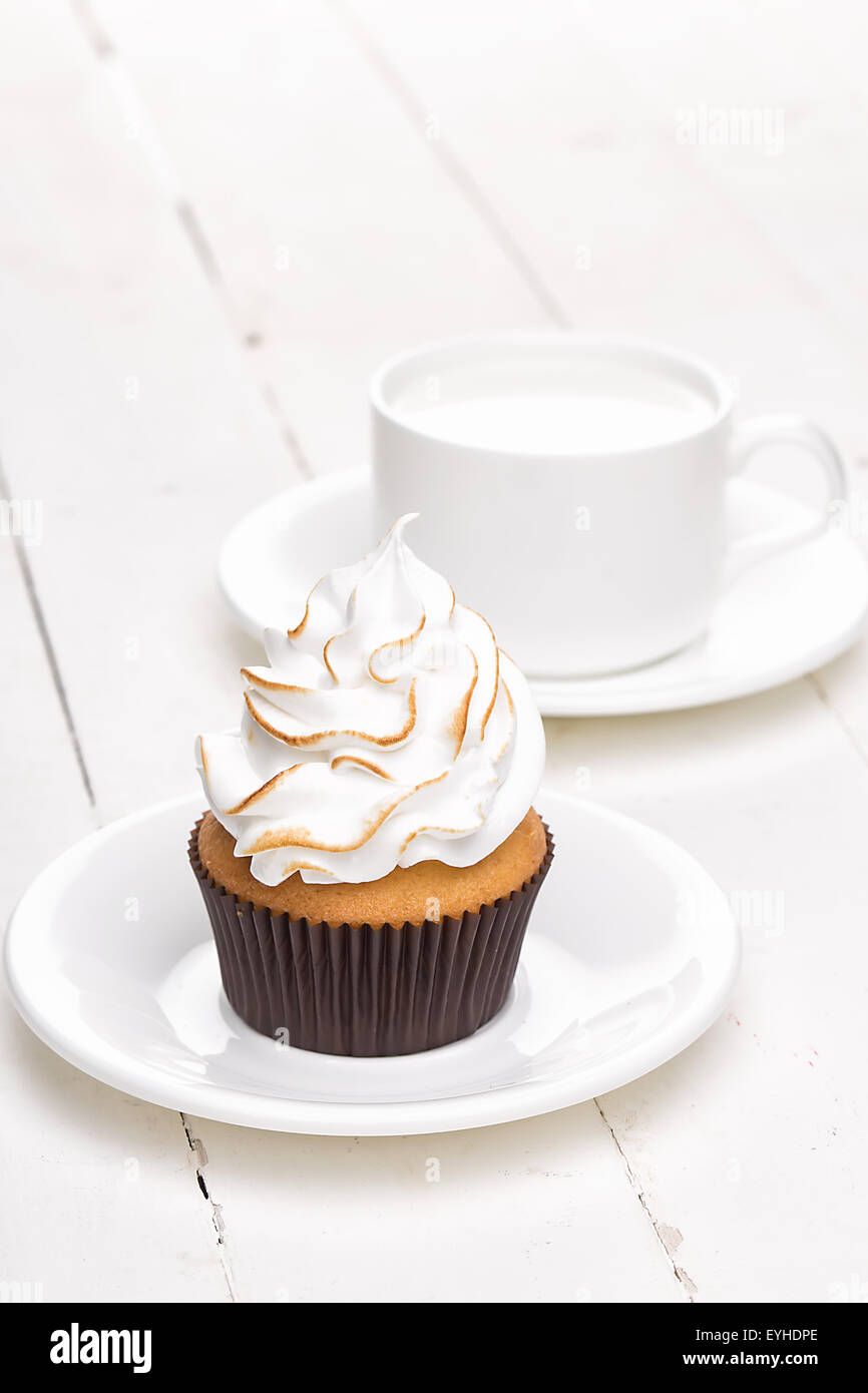 Cupcakes with white cream with cup on white wooden table Stock Photo ...