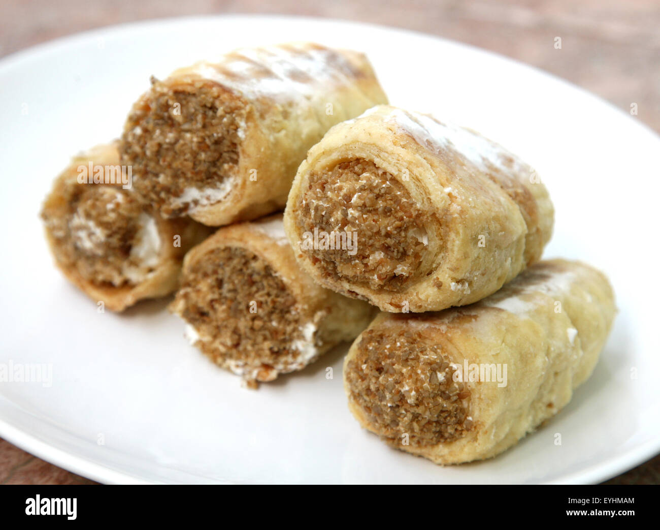 Homemade tube with cream and nuts on white plate Stock Photo - Alamy