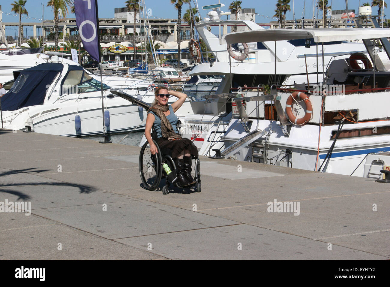 Woman using a wheelchair on a marina dock Stock Photo - Alamy
