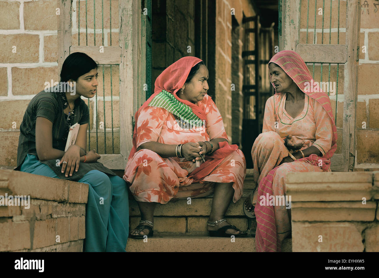Three women gossip outside in one of the narrow streets in late ...