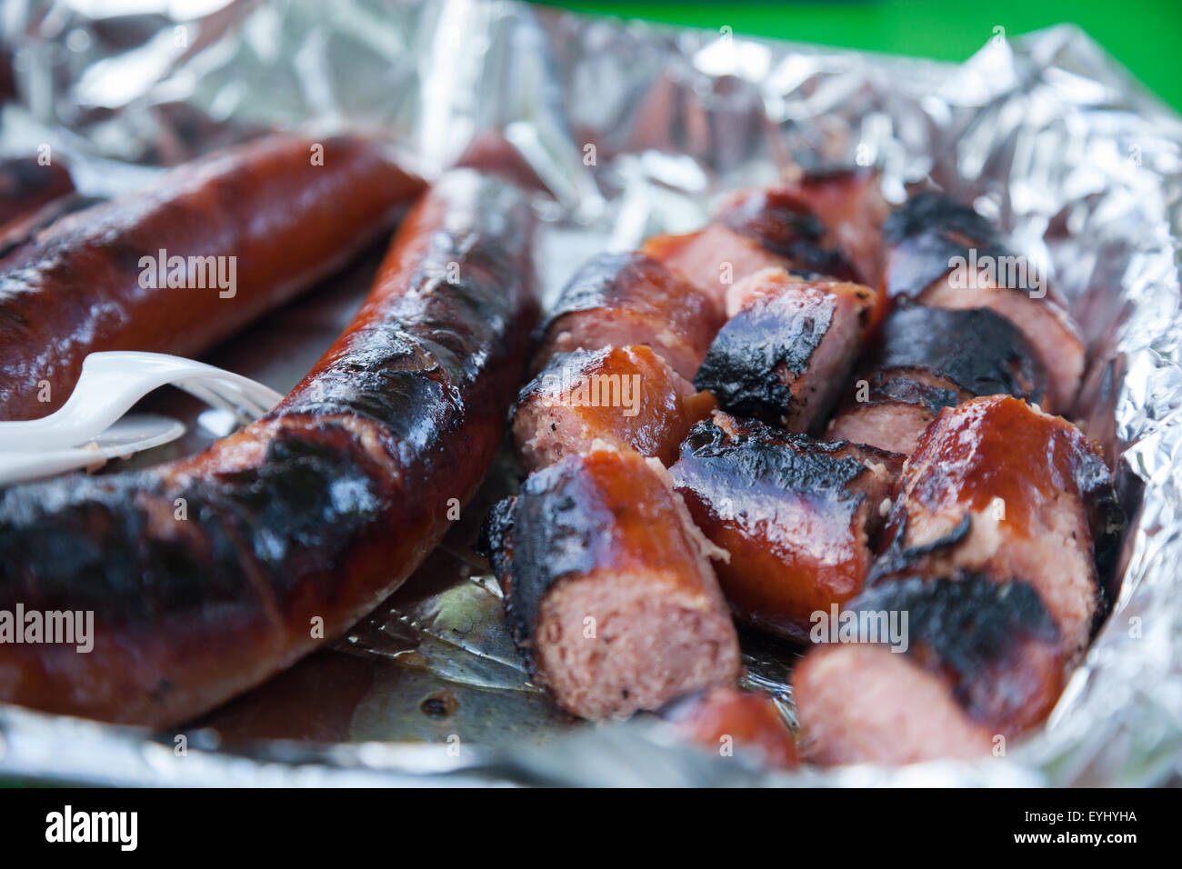 Whole and chopped hot dogs sit inside a foil pan ready to be served ...