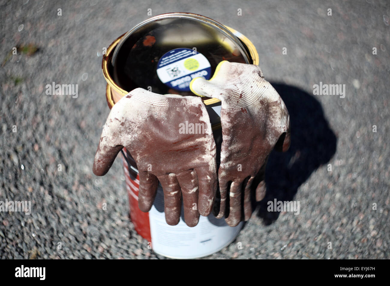 Two used working gloves hanging on empty paint bucket Stock Photo - Alamy