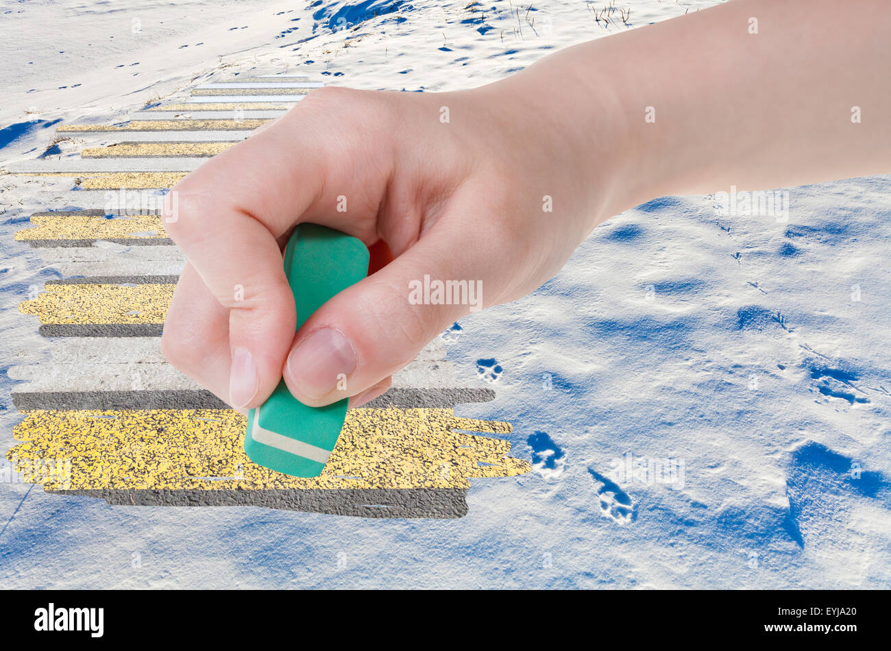 weather concept - hand deletes natural snow field by rubber eraser from ...
