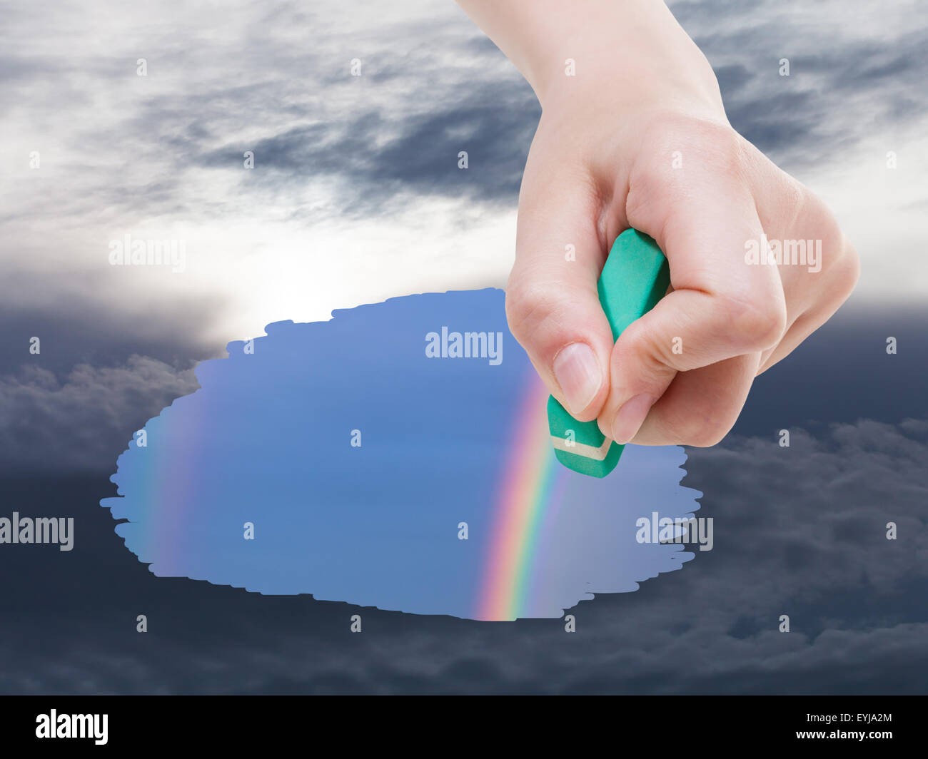 weather concept - hand deletes storm clouds on sky by rubber eraser ...