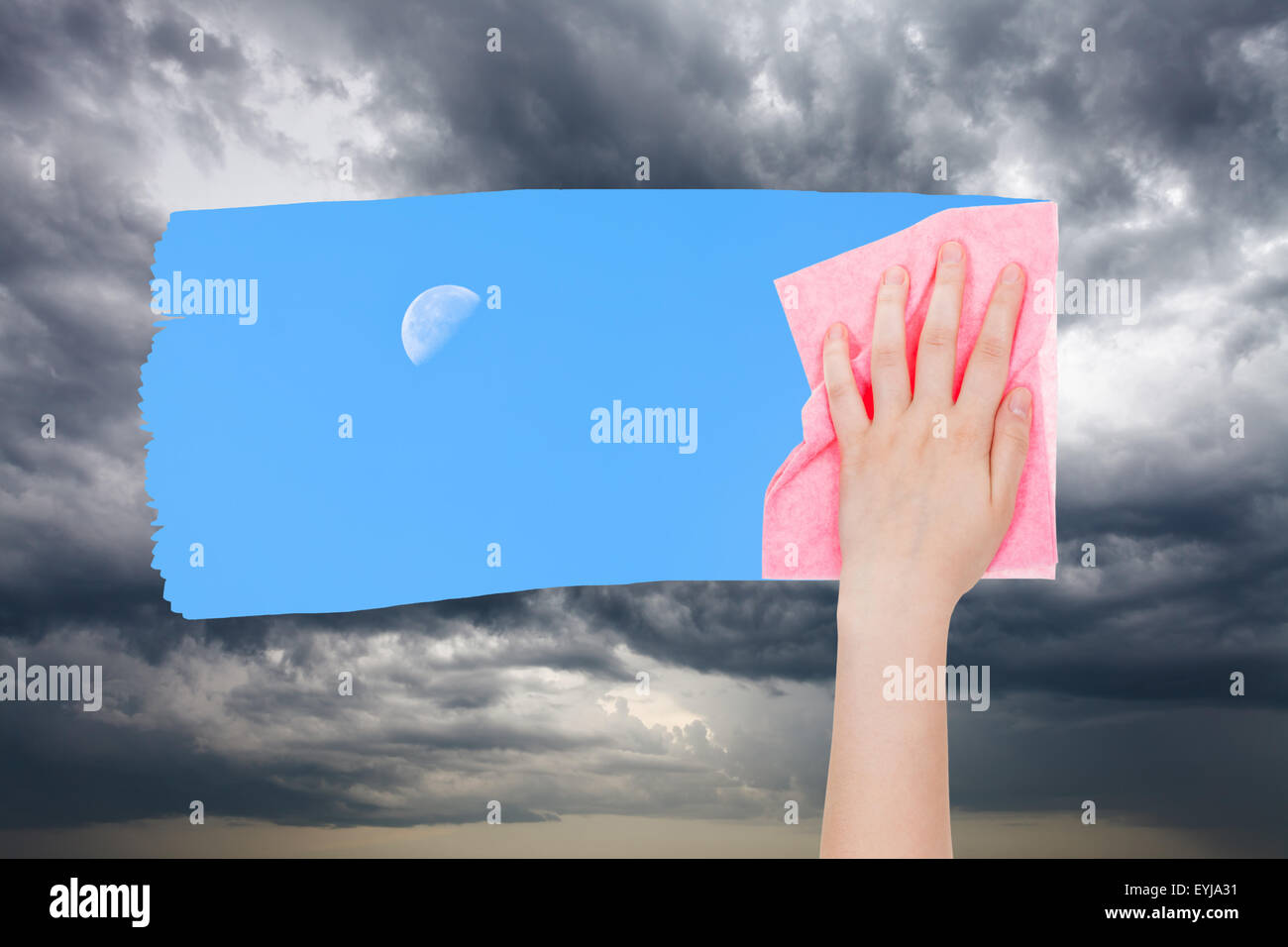 weather concept - hand deletes storm clouds by pink cloth from image ...