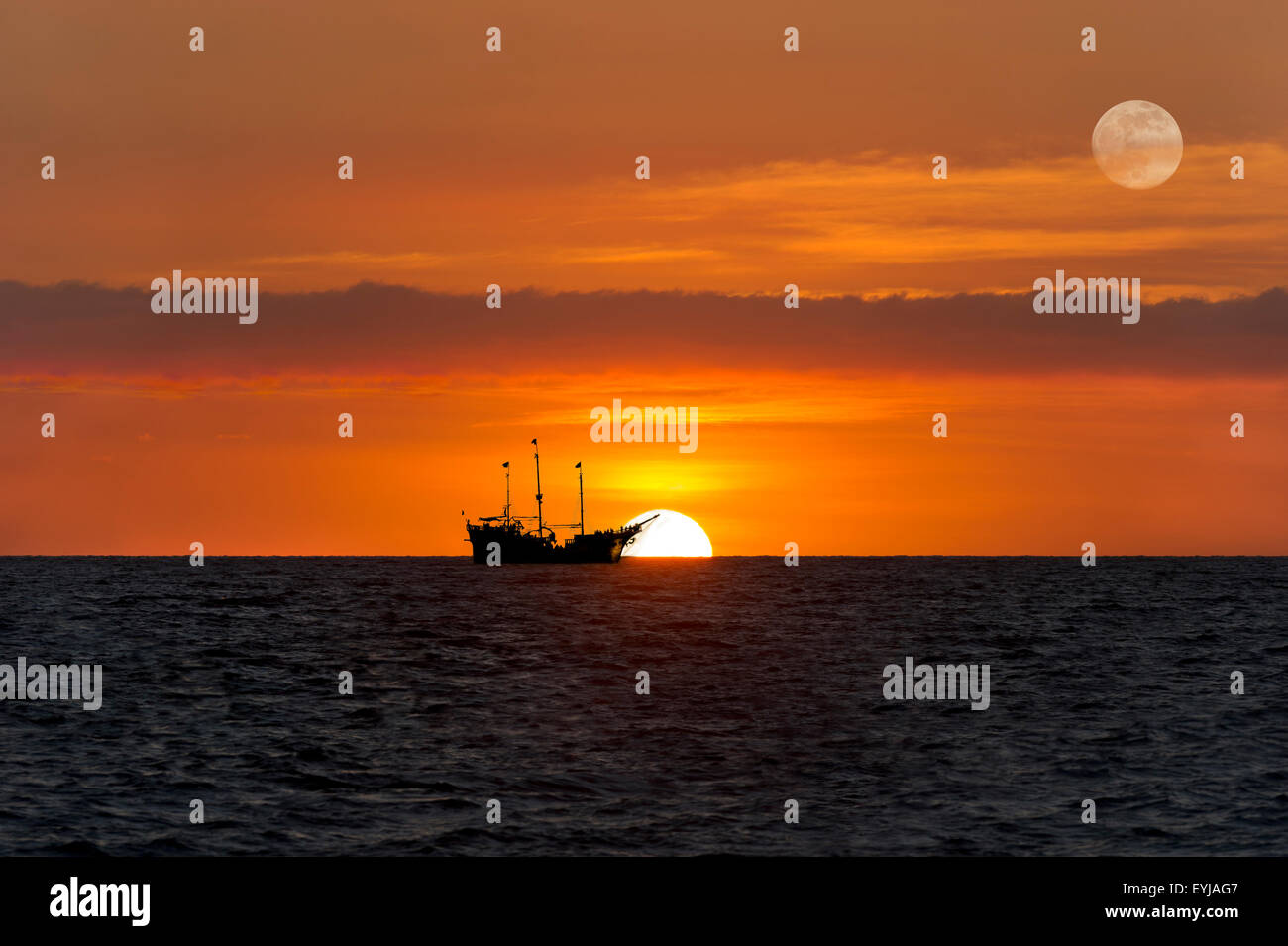 Pirate ship sunset is sailing at sea silhouetted against a setting sun ...