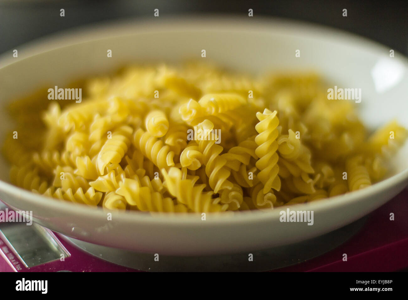 Fusilli pasta in a plate on the digital scale ready to be cooked Stock ...