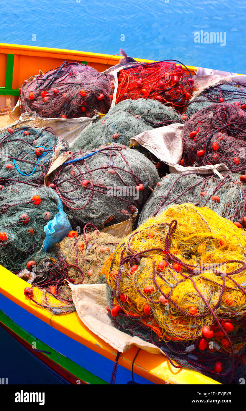 Piles of colorful fishing nets on the dock at Marsaxlokk Stock Photo ...