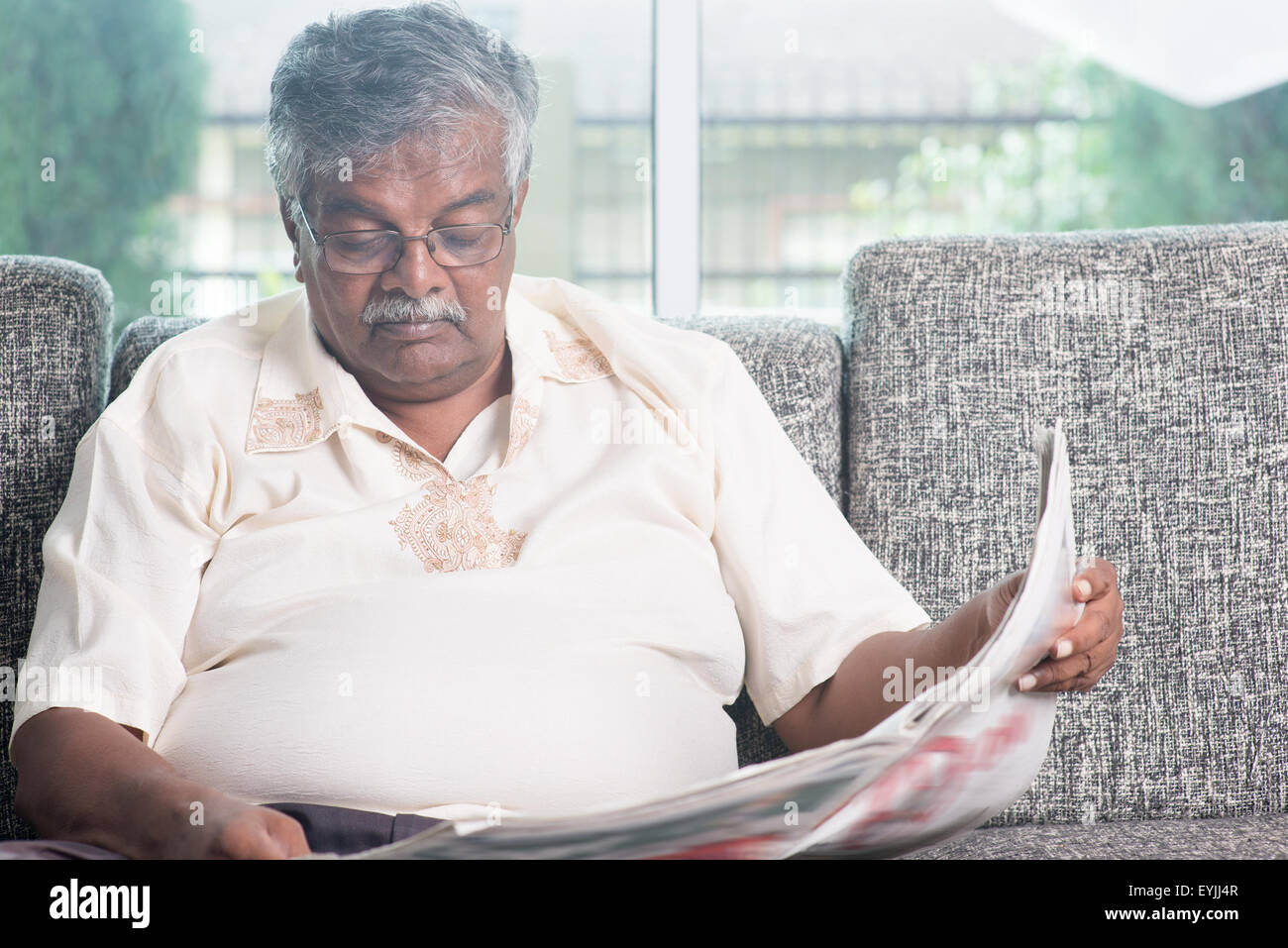 Elder Indian man reading newspaper at home. Asian senior people living ...