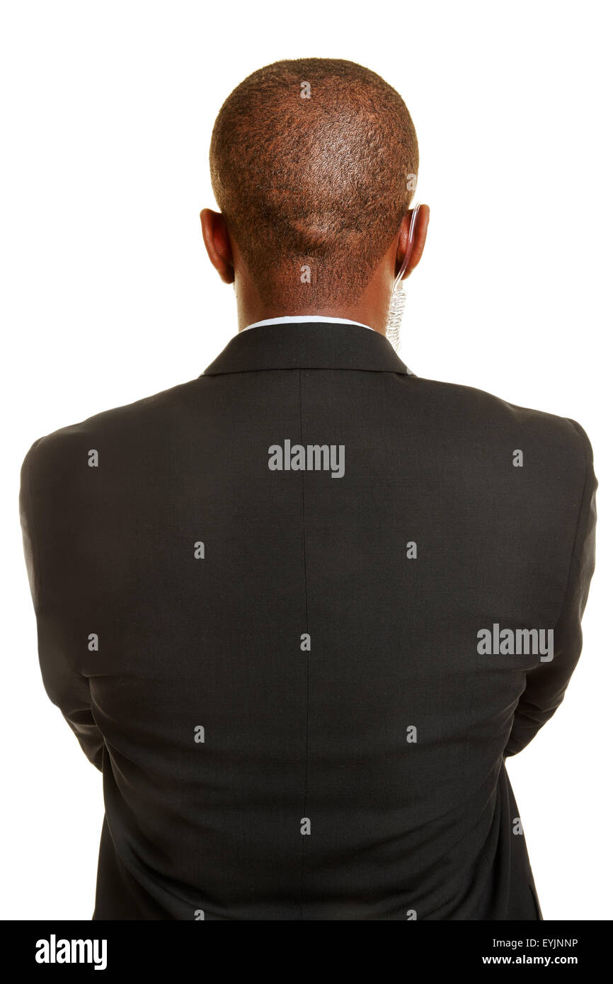 Bodyguard from behind in a suit with headset in ear Stock Photo - Alamy