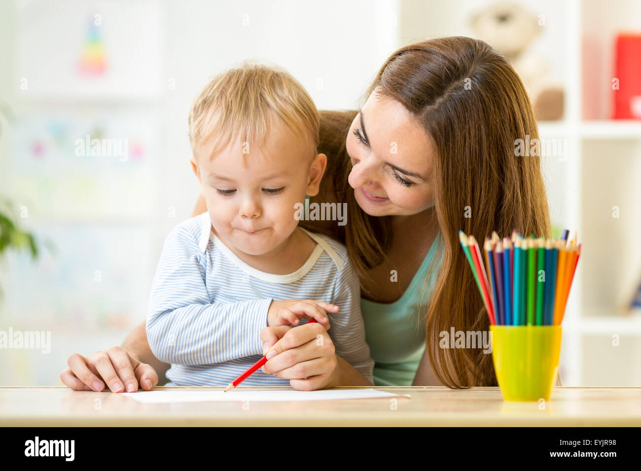 cute child drawing with mother help Stock Photo - Alamy