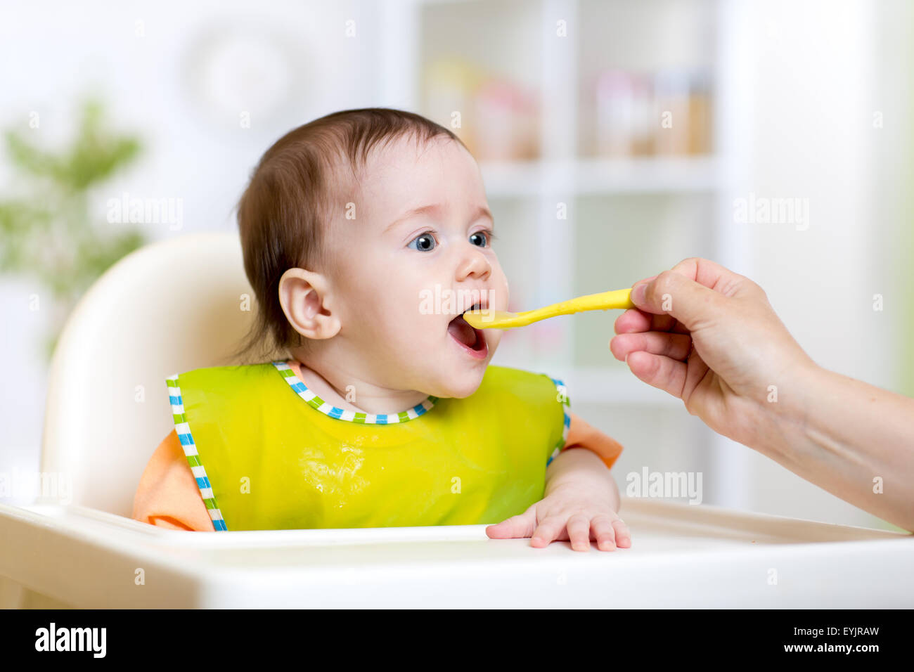 kid girl eating with spoon indoors Stock Photo - Alamy