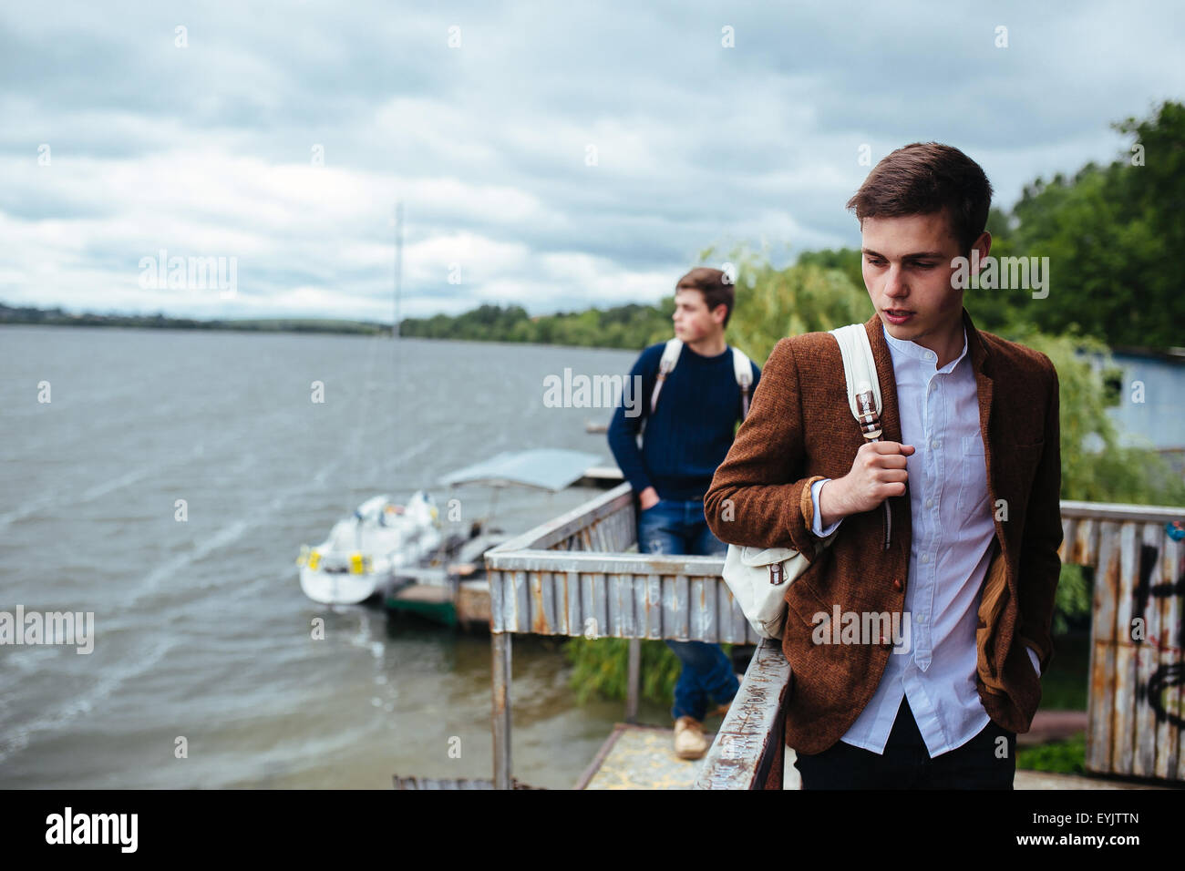 two young guys standing on a pier Stock Photo - Alamy