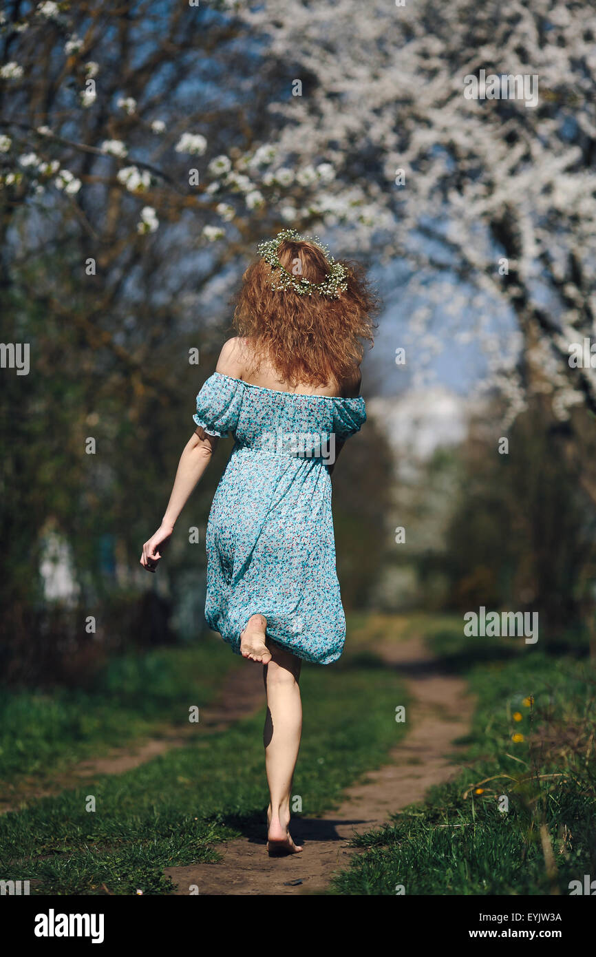 Beautiful girl follows a country road Stock Photo - Alamy