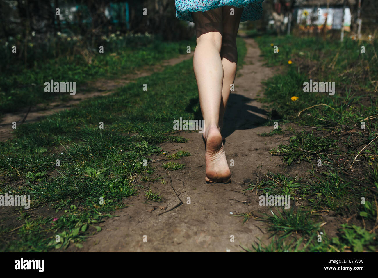 Beautiful girl legs follows a country road Stock Photo - Alamy