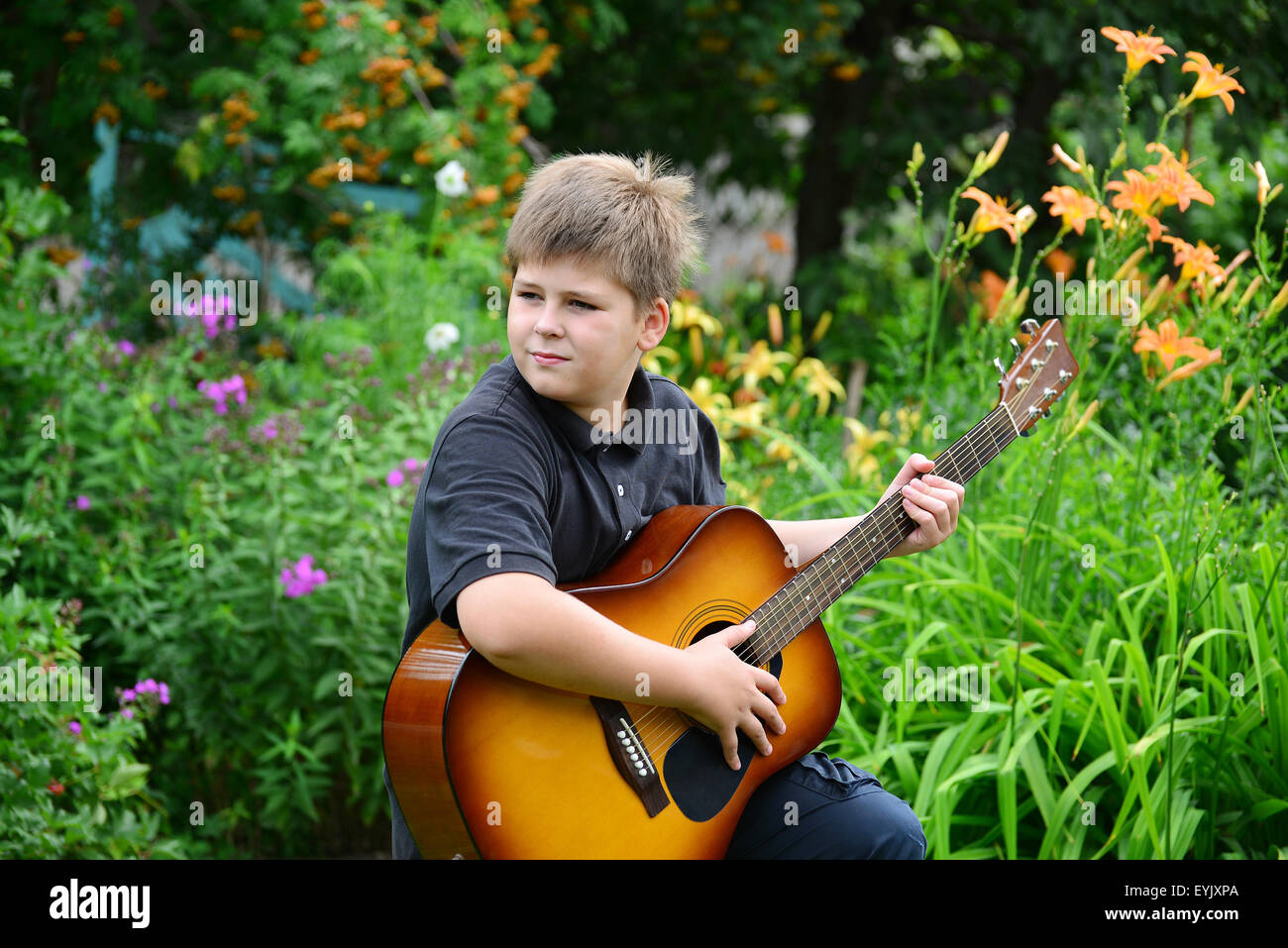 Teen boy playing guitar outdoor in summer Stock Photo - Alamy