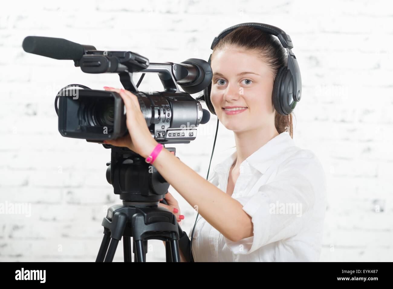 a pretty young woman with a professional camera and headphone Stock ...