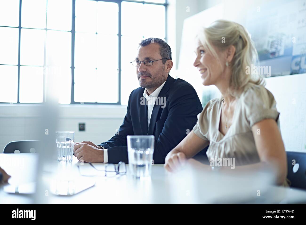 Businesswoman and man at conference table in office meeting Stock Photo ...