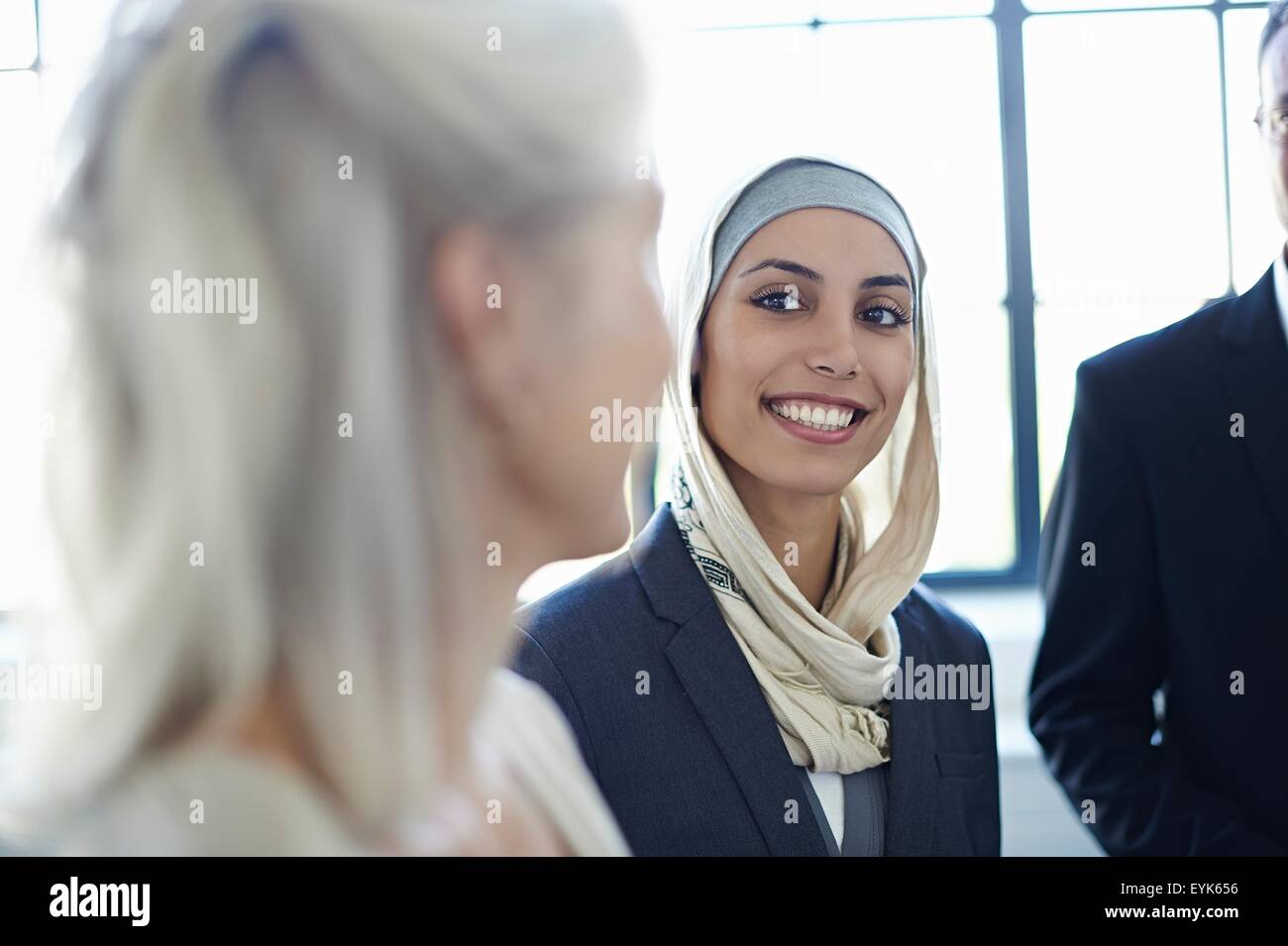 Over shoulder view of businesswomen chatting in office Stock Photo - Alamy