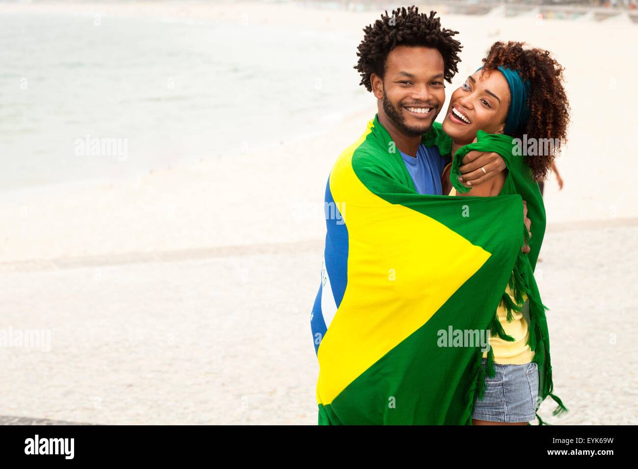 Couple hugging wrapped in Brazilian flag on Ipanema beach, Rio De ...