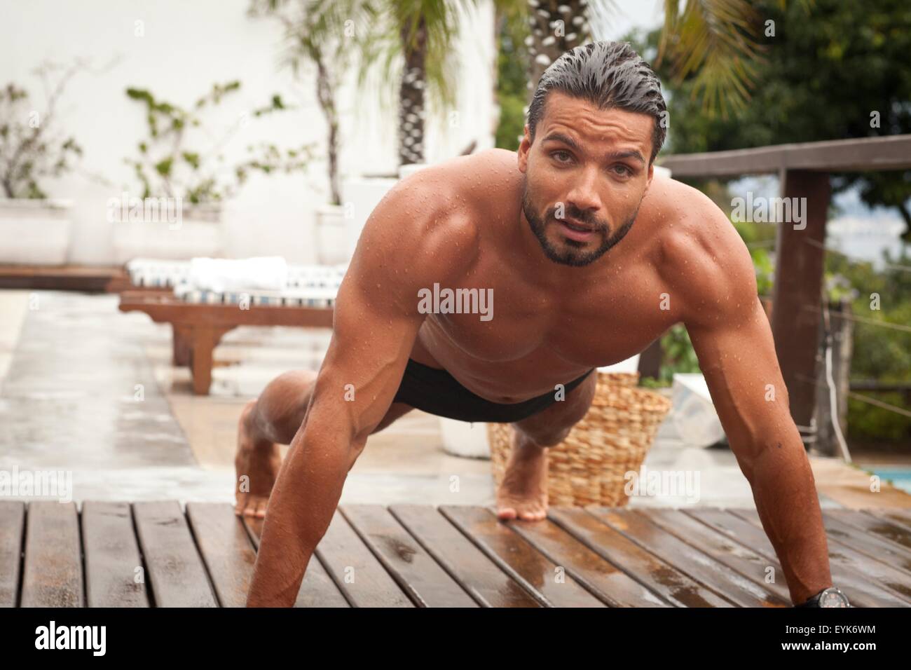Man doing push ups by poolside Stock Photo - Alamy