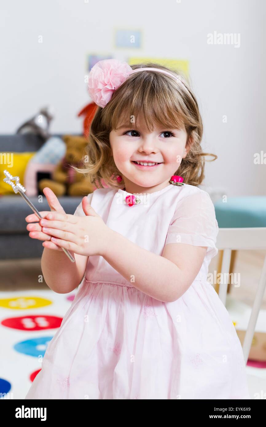 Girl in pink dress holding magic wand at home Stock Photo - Alamy