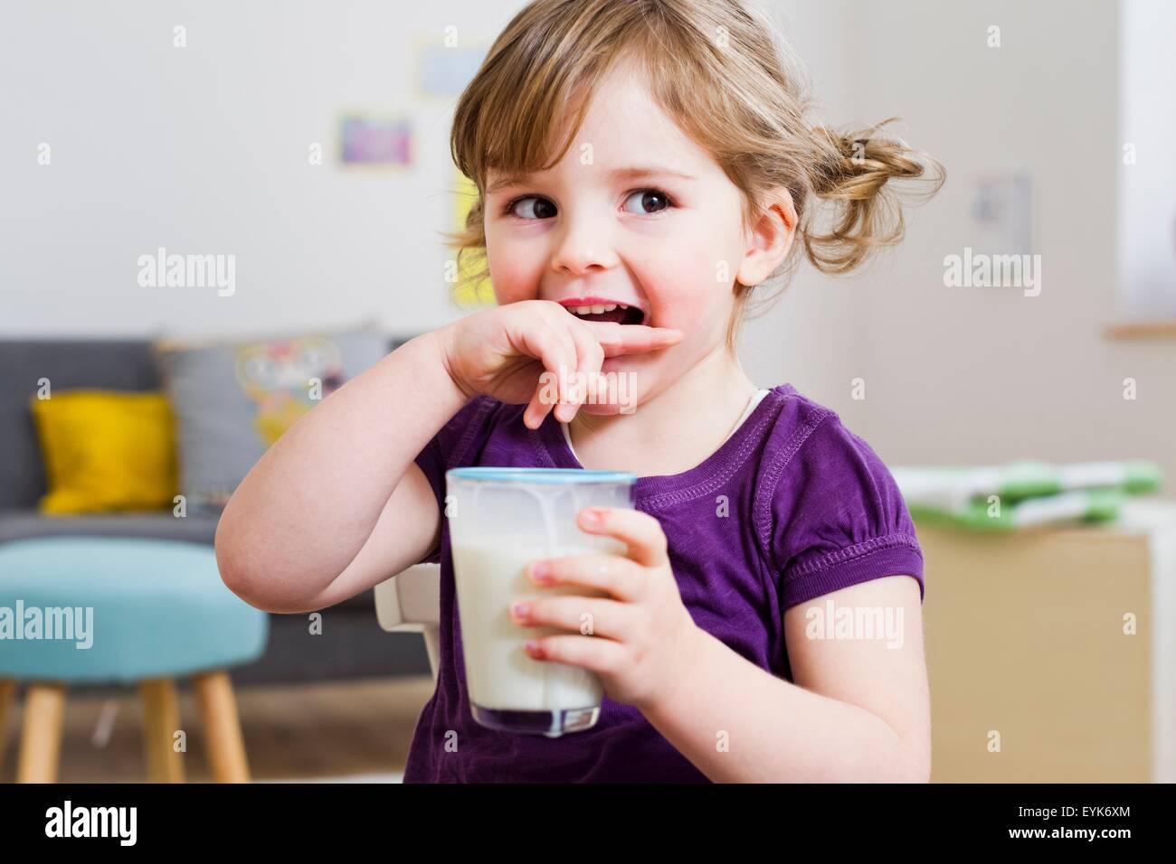 Girl on gray sofa holding hi-res stock photography and images - Alamy