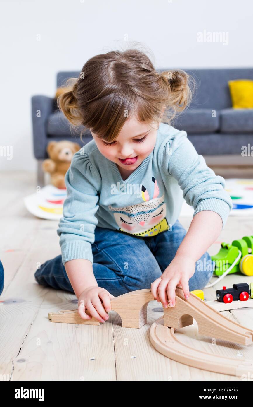 Girl playing with toy cars at home Stock Photo - Alamy