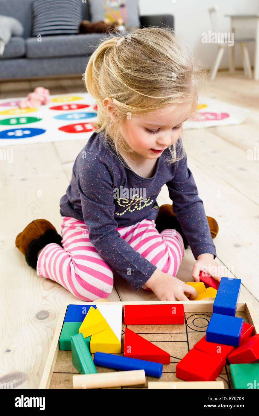 Girl playing with building blocks at home Stock Photo - Alamy