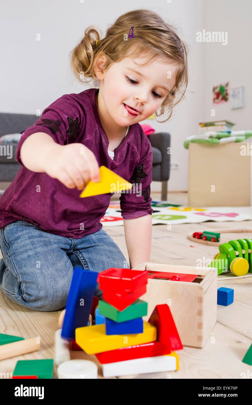 Girl playing with building blocks at home Stock Photo - Alamy