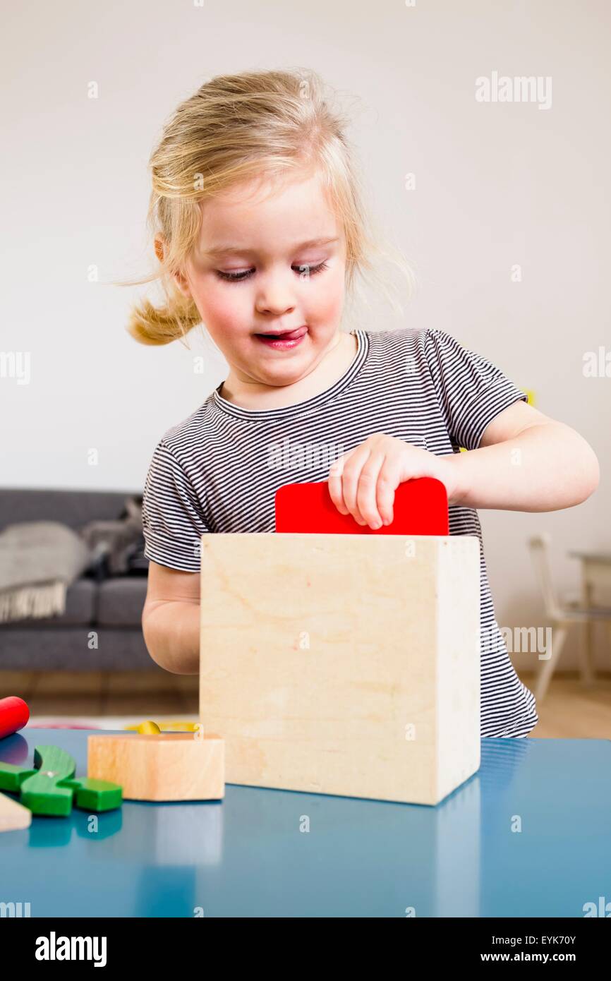 Girl playing with building blocks at home Stock Photo - Alamy