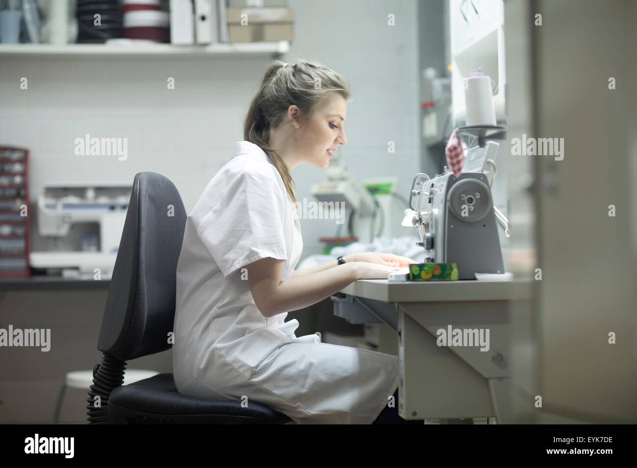 Woman working at sewing machine at laundry Stock Photo - Alamy