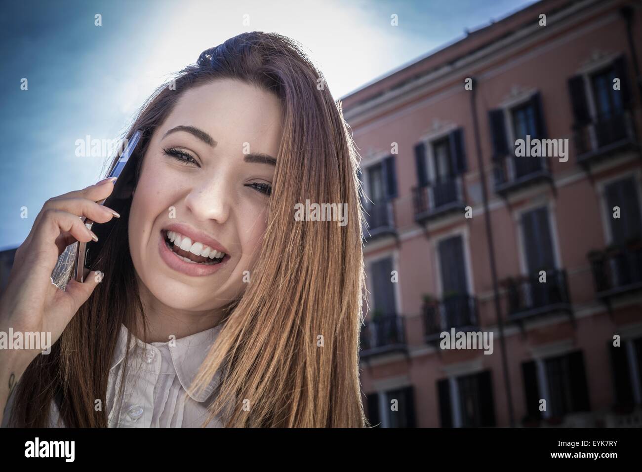 Young woman in street talking on smartphone, Cagliari, Sardinia, Italy ...