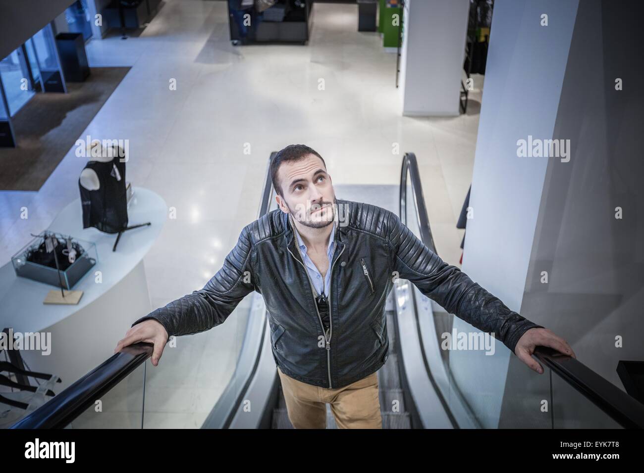 Man moving up escalator in shopping mall Stock Photo - Alamy