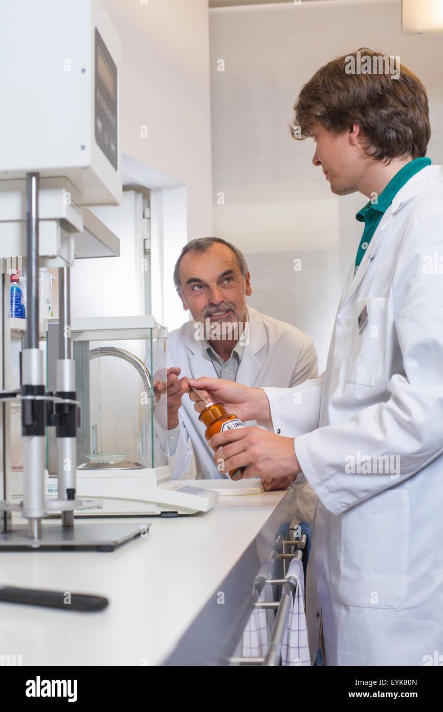 Pharmacist and trainee mixing medicine in pharmacy Stock Photo - Alamy