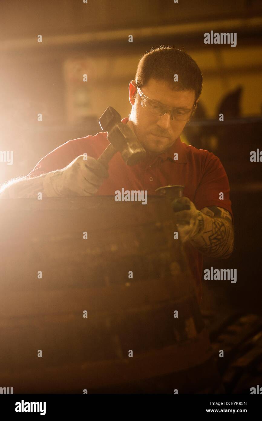Male cooper using hammer in cooperage with whisky cask Stock Photo - Alamy