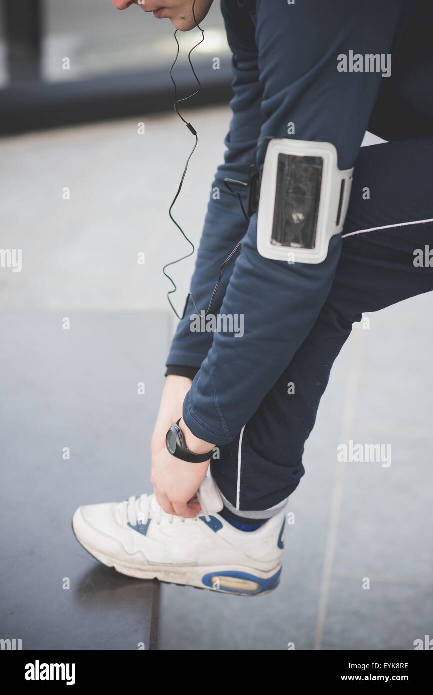 Cropped shot of young male runner fastening trainer lace Stock Photo ...