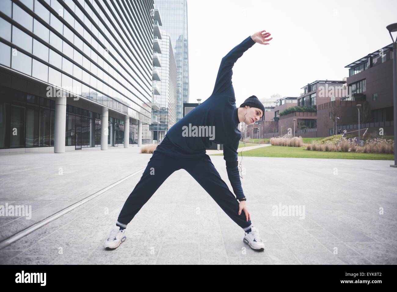 Young male runner stretching in city Stock Photo - Alamy