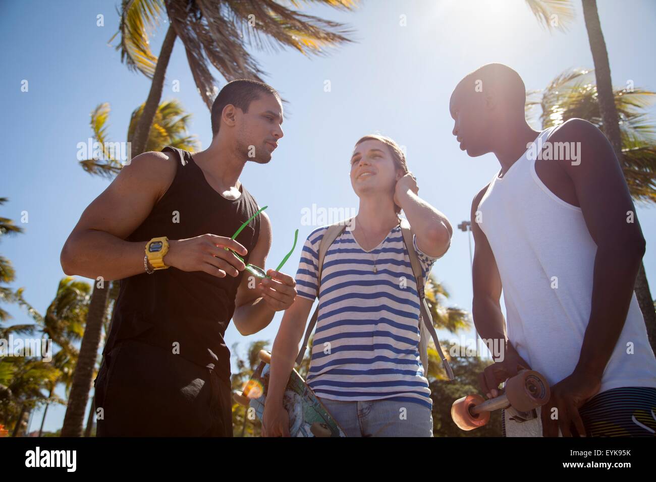 Three young men talking, low angle Stock Photo - Alamy