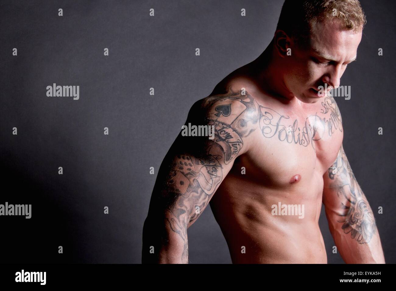 Muscular young man with tattoos Stock Photo - Alamy