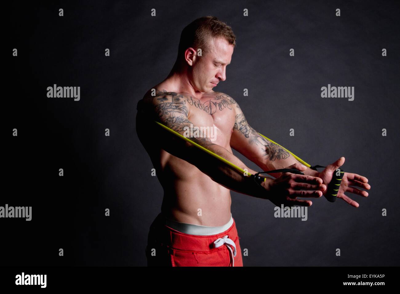 Young man using resistance band Stock Photo - Alamy