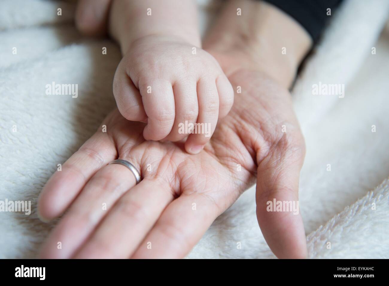 Baby boy's hand resting on mother's hand, close-up Stock Photo - Alamy