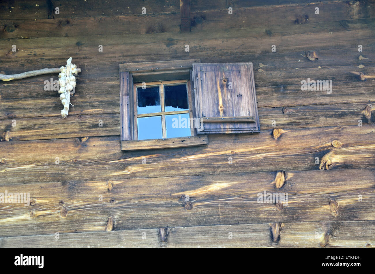 Old wooden window of a traditional village house with garlic garland ...