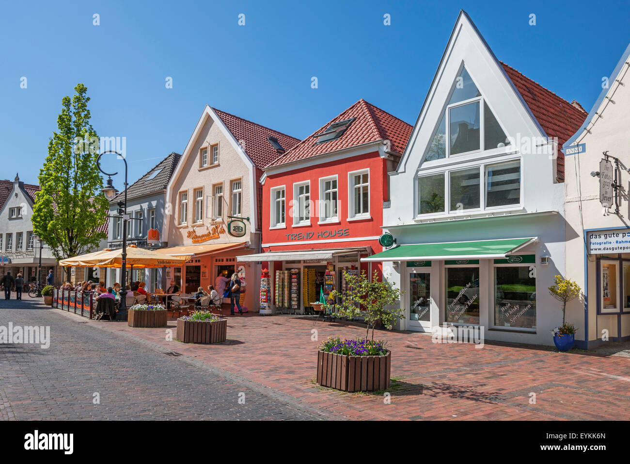 Shops, street café at churchyard at Old Town of Jever, Friesland, Lower ...