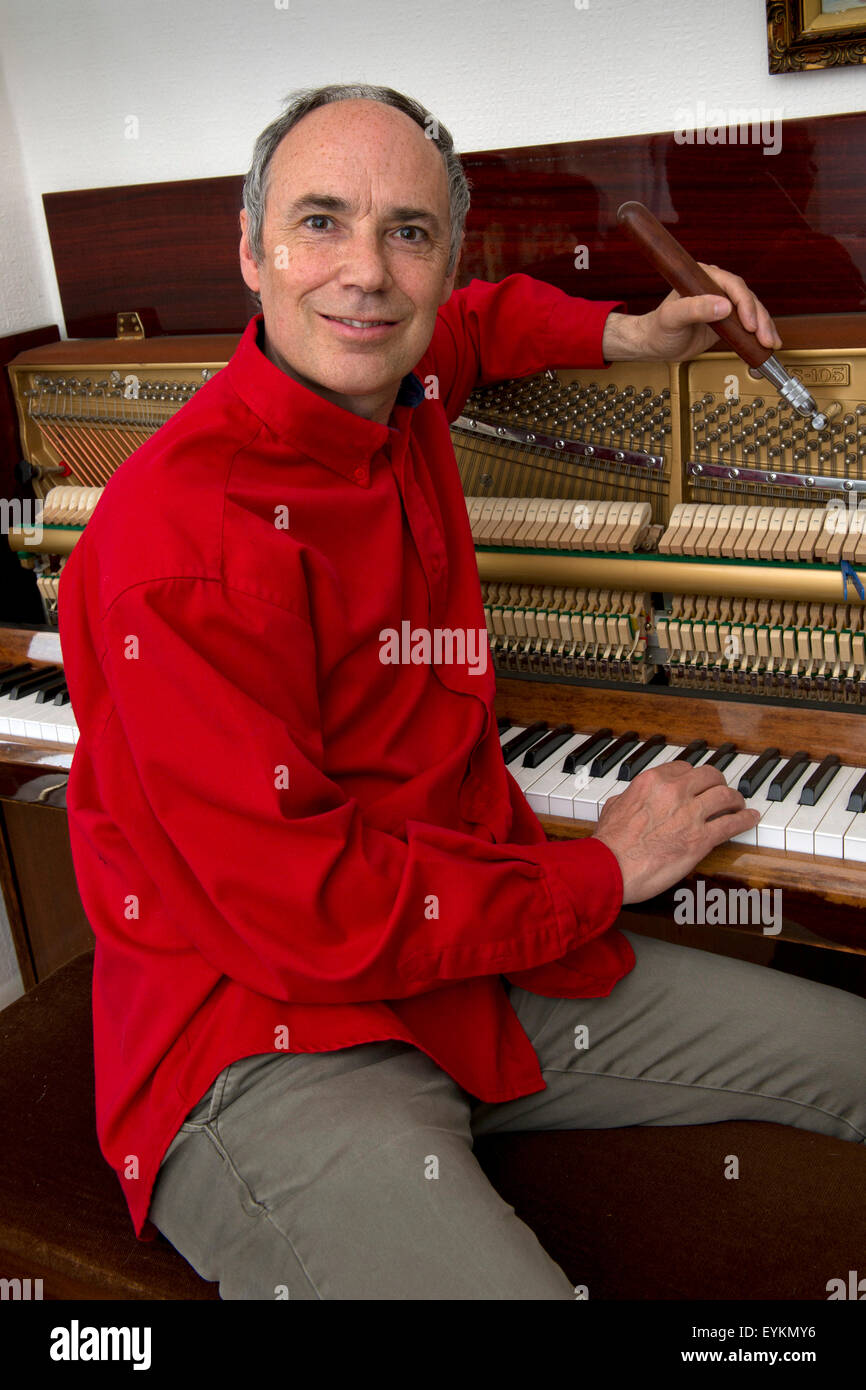 Piano tuner Chris Jewell working on an upright piano,a musical ...