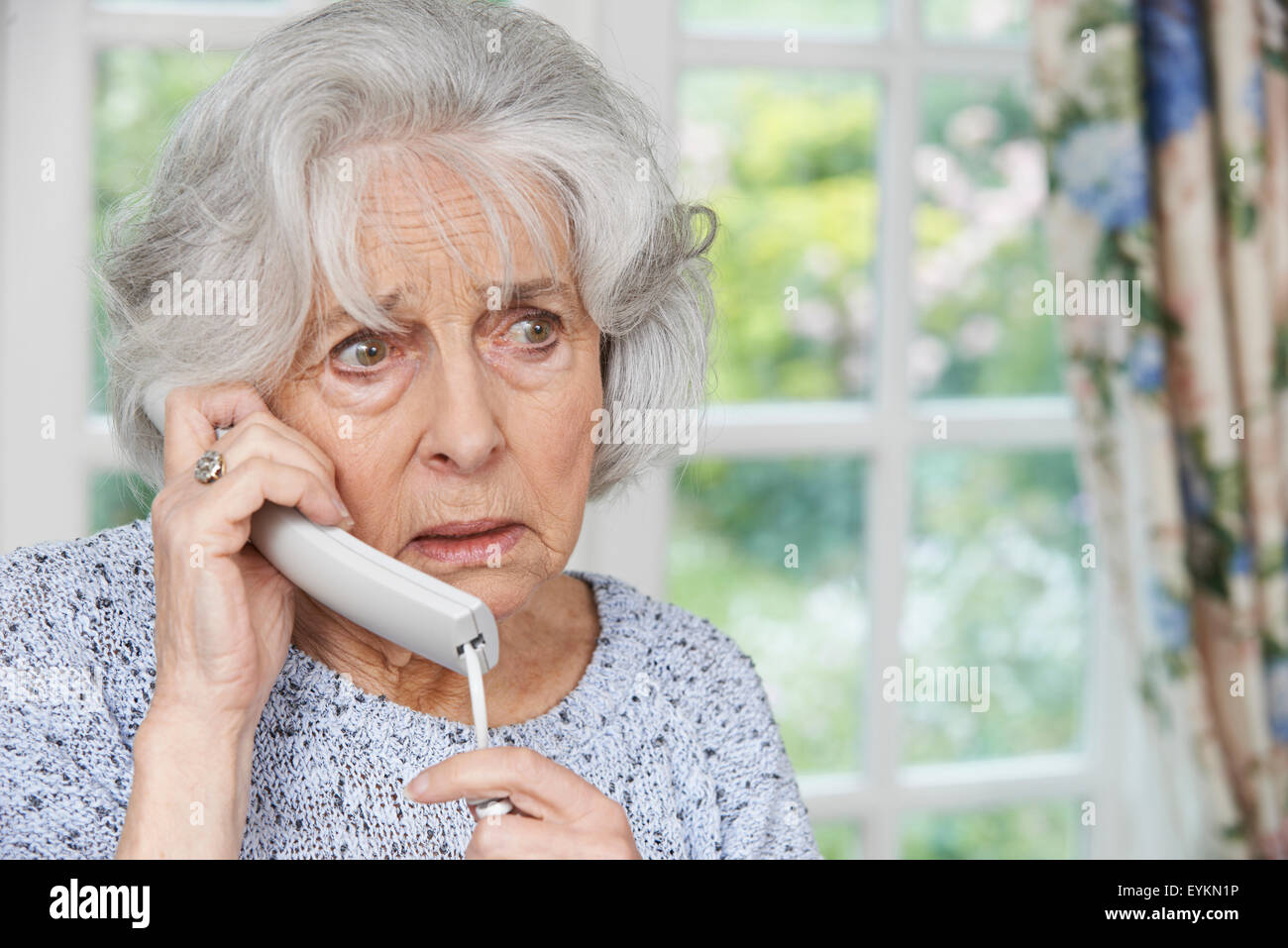 Worried Senior Woman Answering Telephone At Home Stock Photo - Alamy