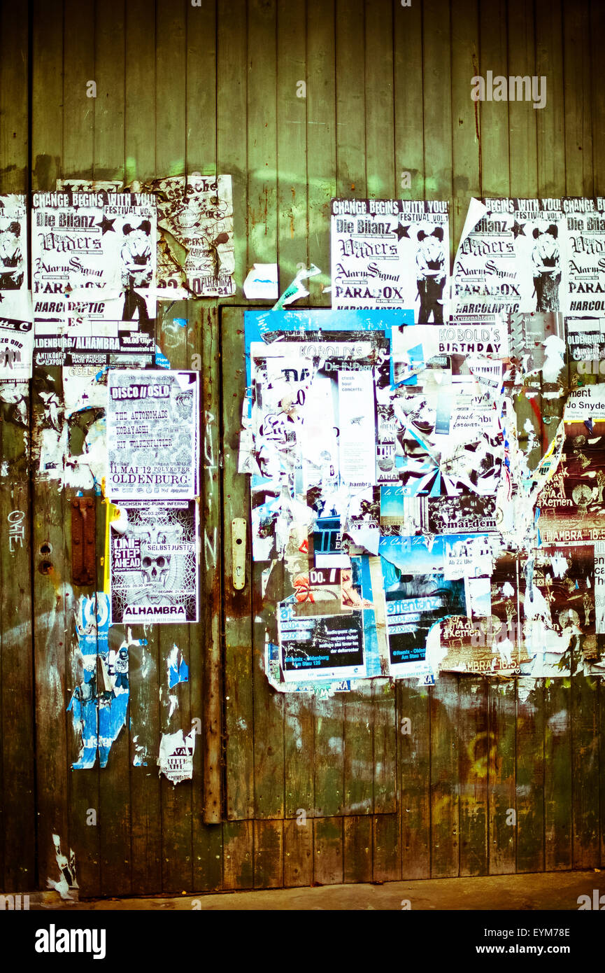 Wooden wall with ragged posters Stock Photo - Alamy