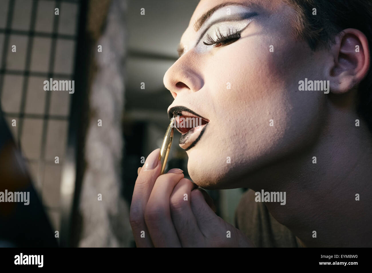 Male drag queen putting on make up and dressing up in preparation for a ...