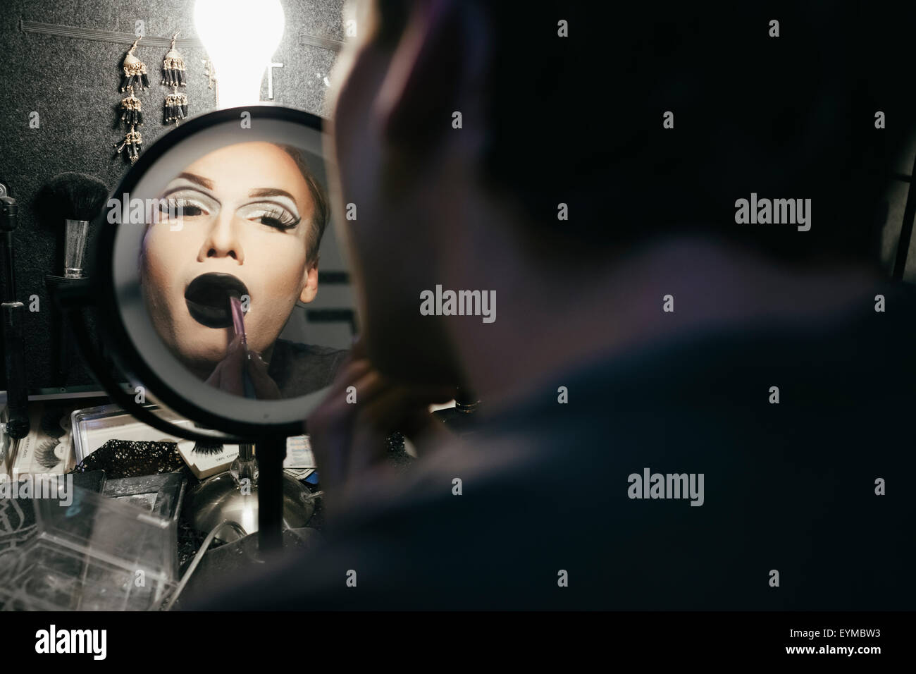 Male drag queen putting on make up and dressing up in preparation for a ...